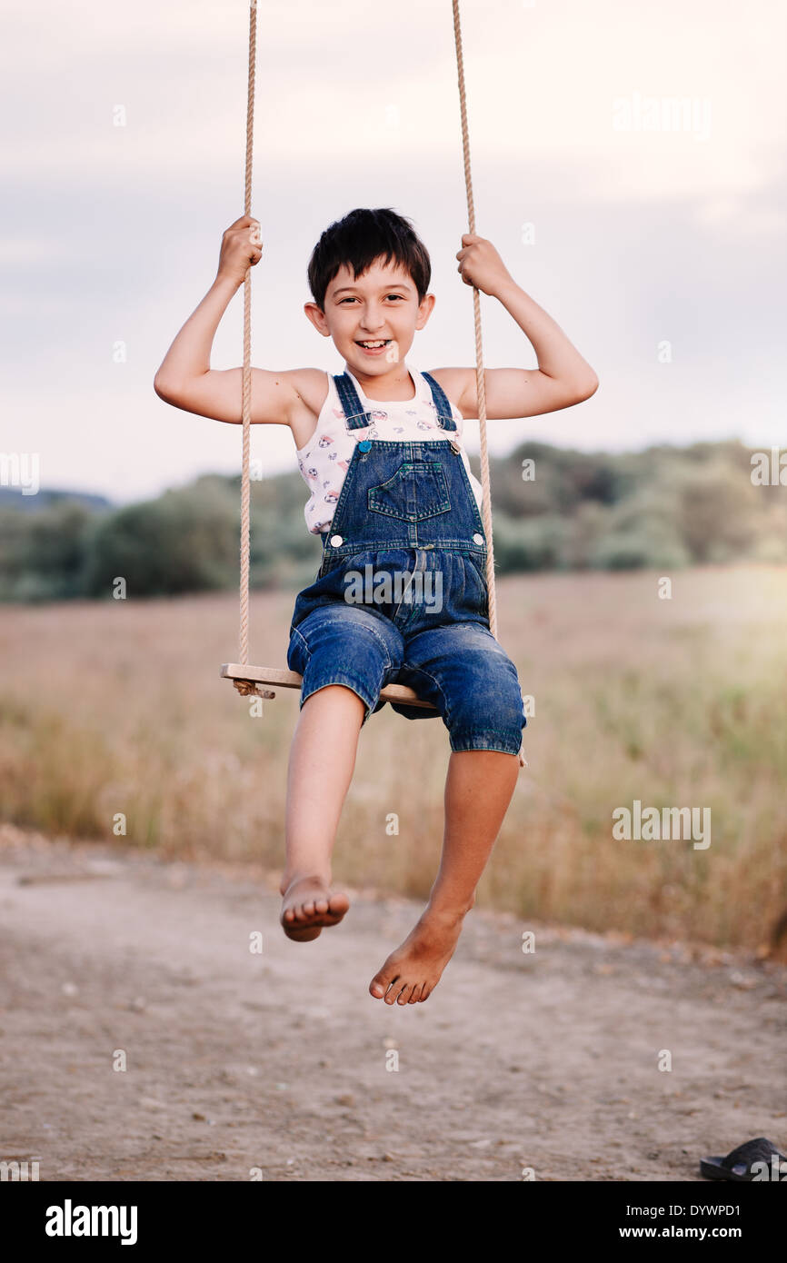 Boy playing on swing in hi-res stock photography and images - Alamy