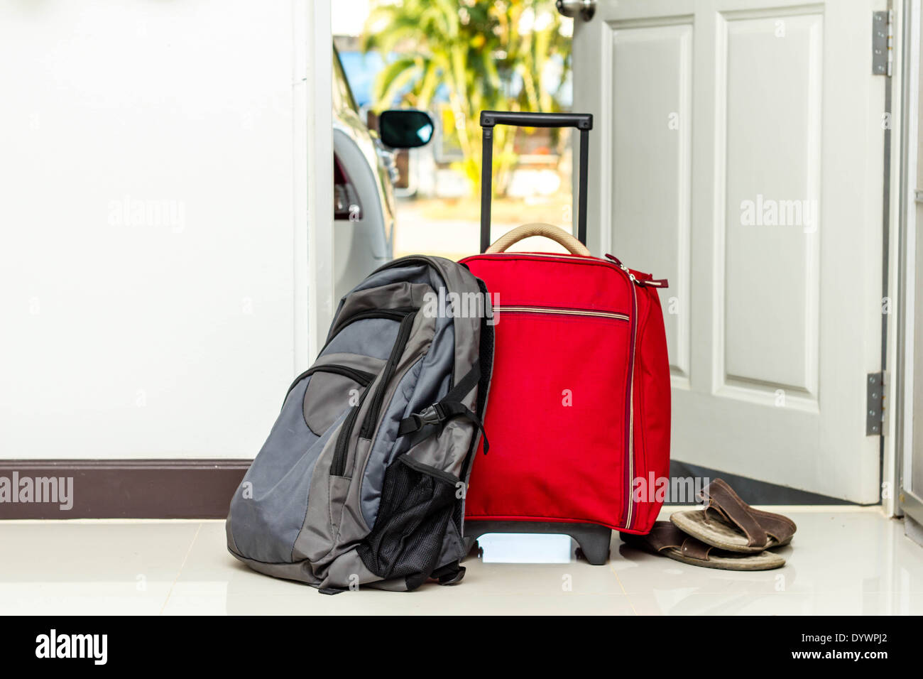 red travel bag , backpack and shoes by front door Stock Photo - Alamy