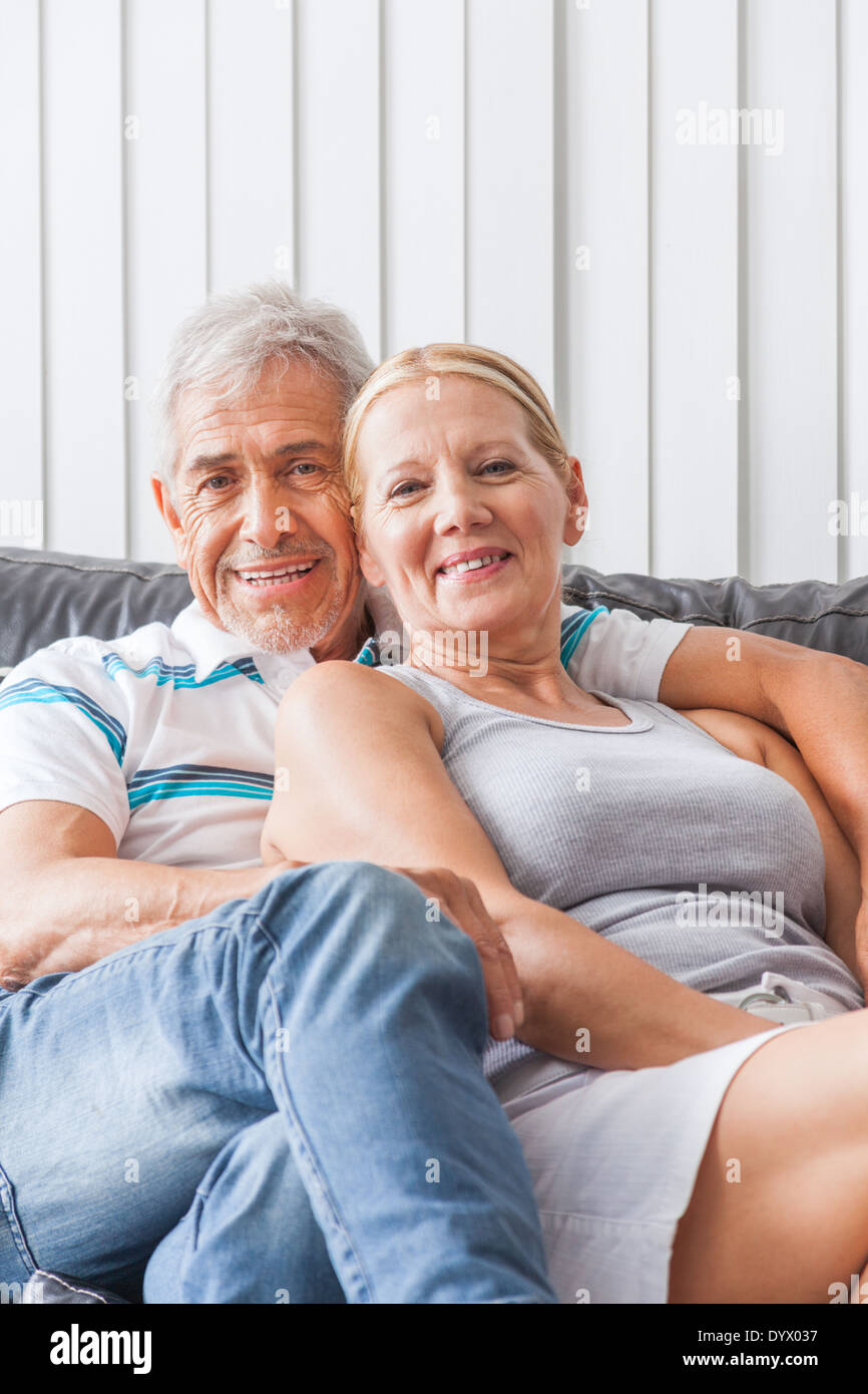 Laughing embracing caucasian couple sitting hi-res stock photography ...