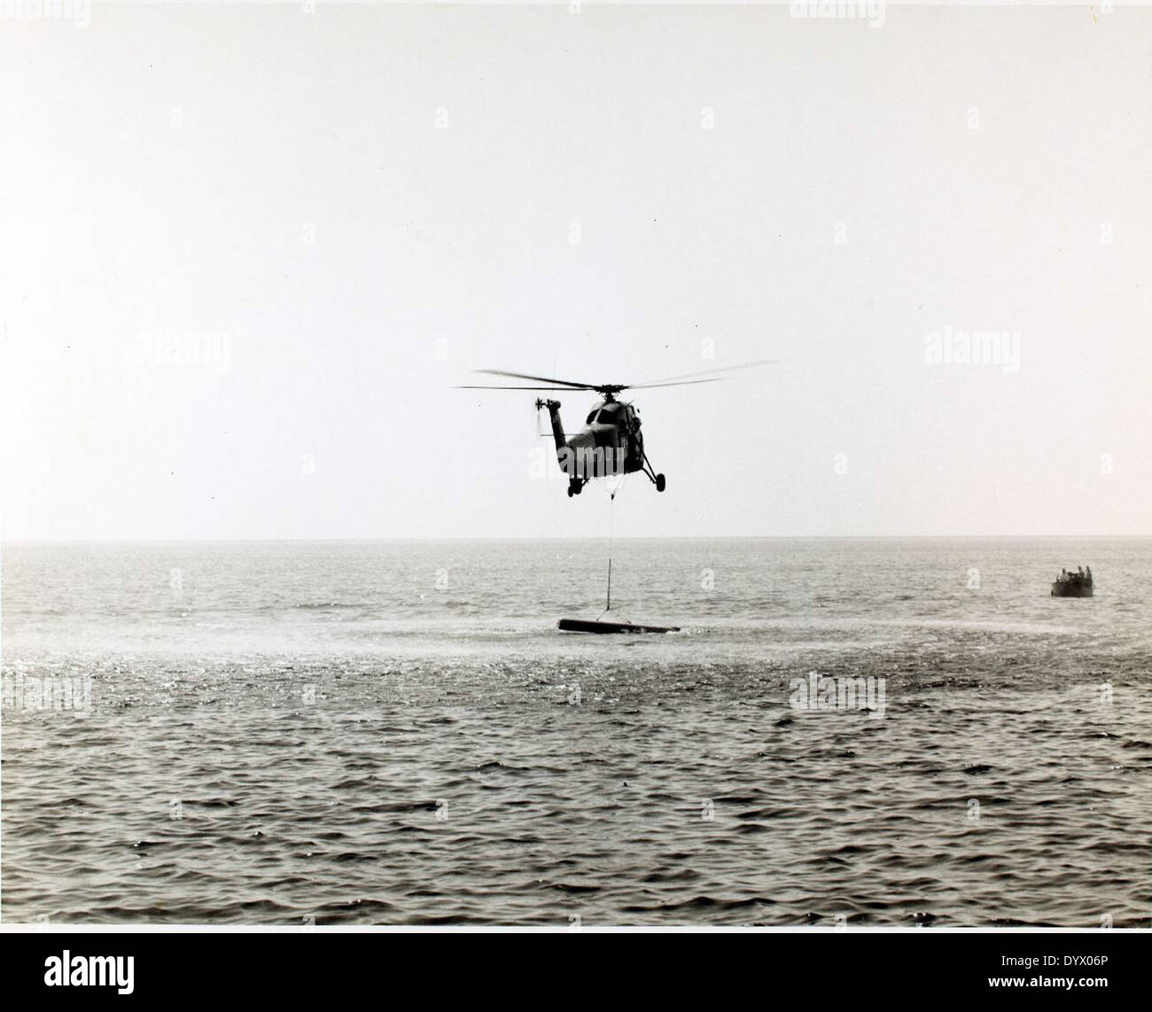 This photograph shows a Sikorsky H-34 helicopter flying above the ocean ...