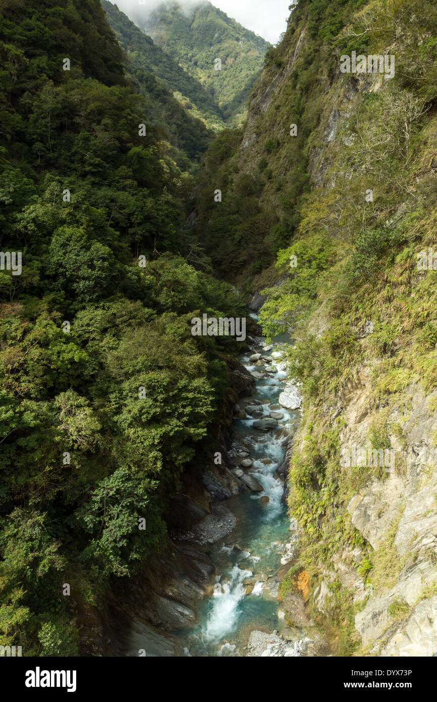 Landscape of lush and steep mountains, ravine and rocky river at the ...