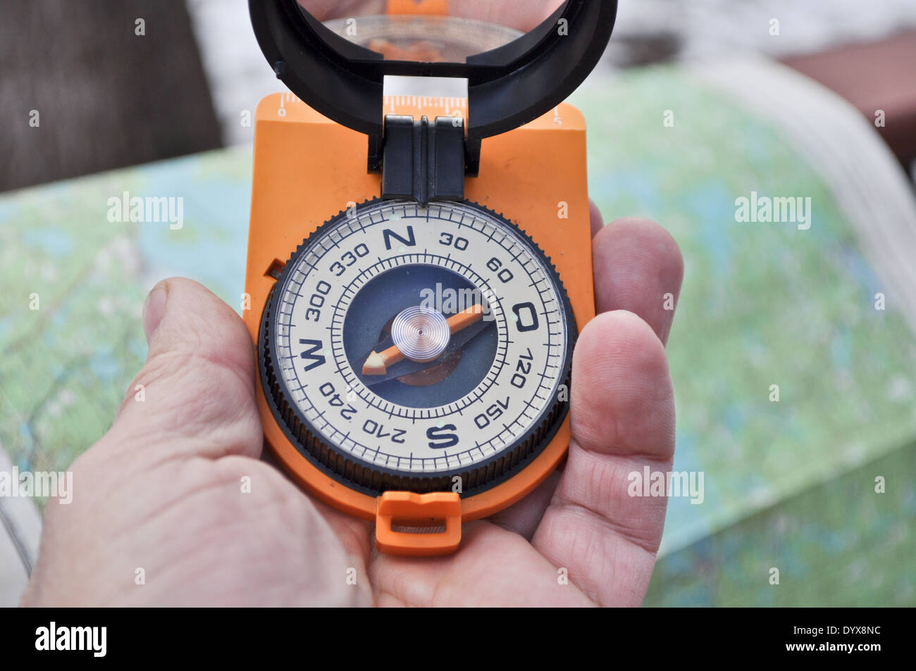 Magnetic compass in the black case on an orange ground with mirror ...