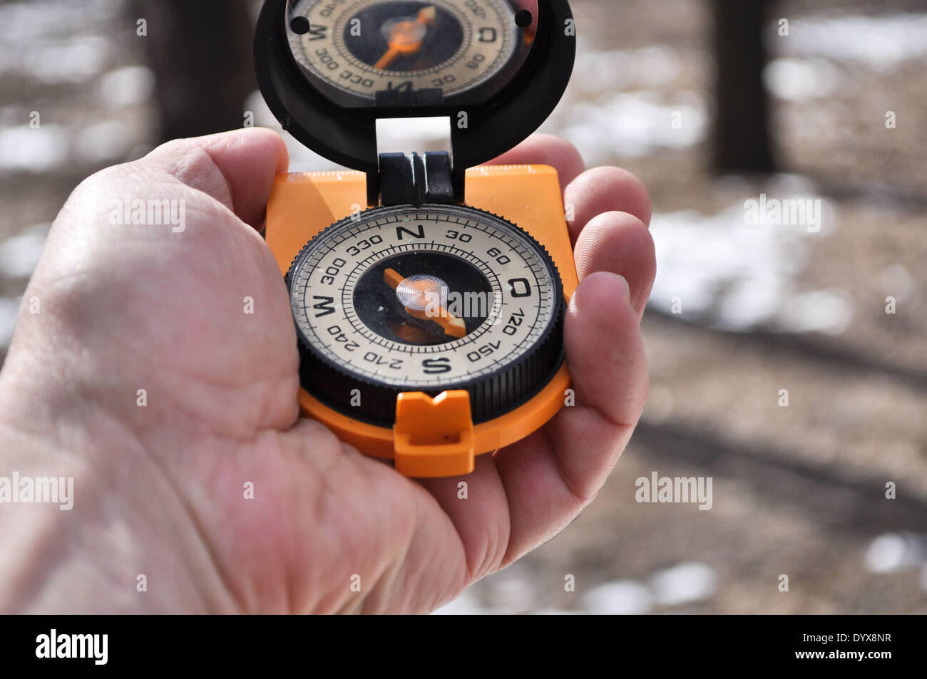 Magnetic compass in the black case on an orange ground with mirror ...