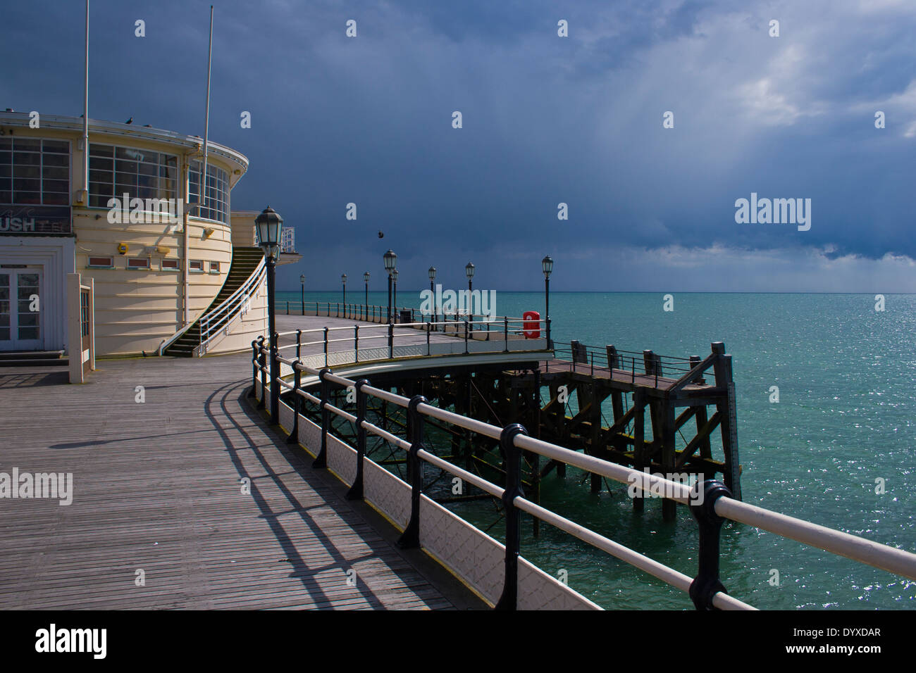secluded view down the curve of wooden pier to observation building at ...