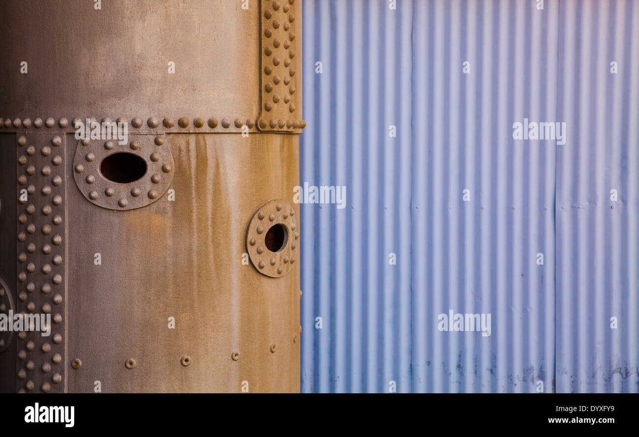 A riveted iron rounded from next to a corrugated iron sheet wall Stock ...