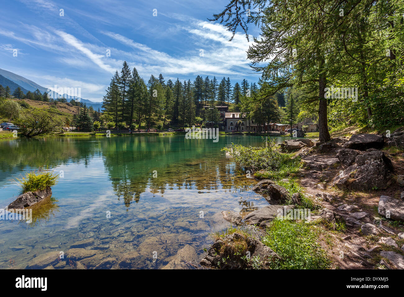 Small alpine lake Laux surrounded by trees in Italian Alps Stock Photo ...
