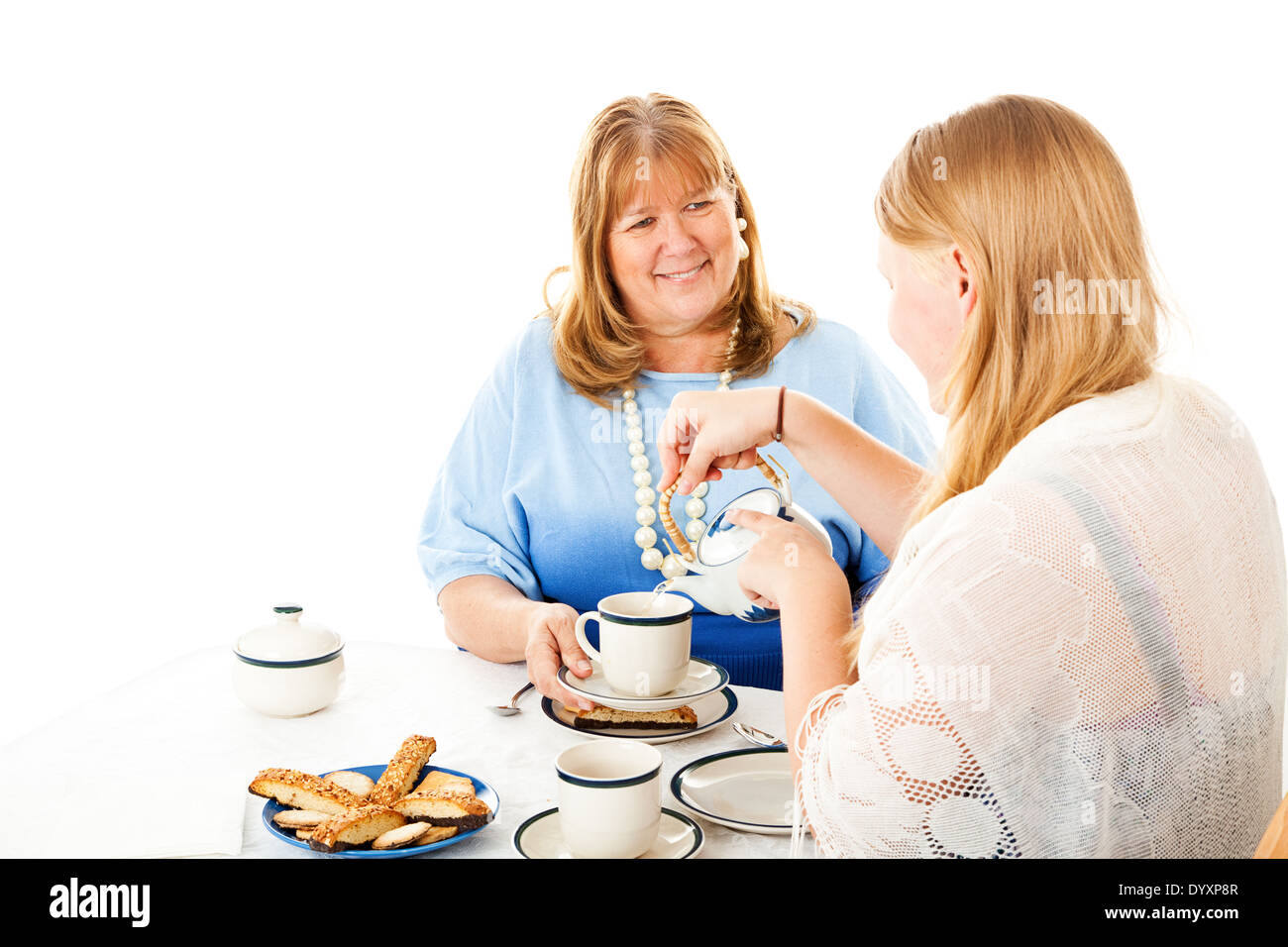 Teen daughter pouring tea for her mother at their tea party. Isolated ...