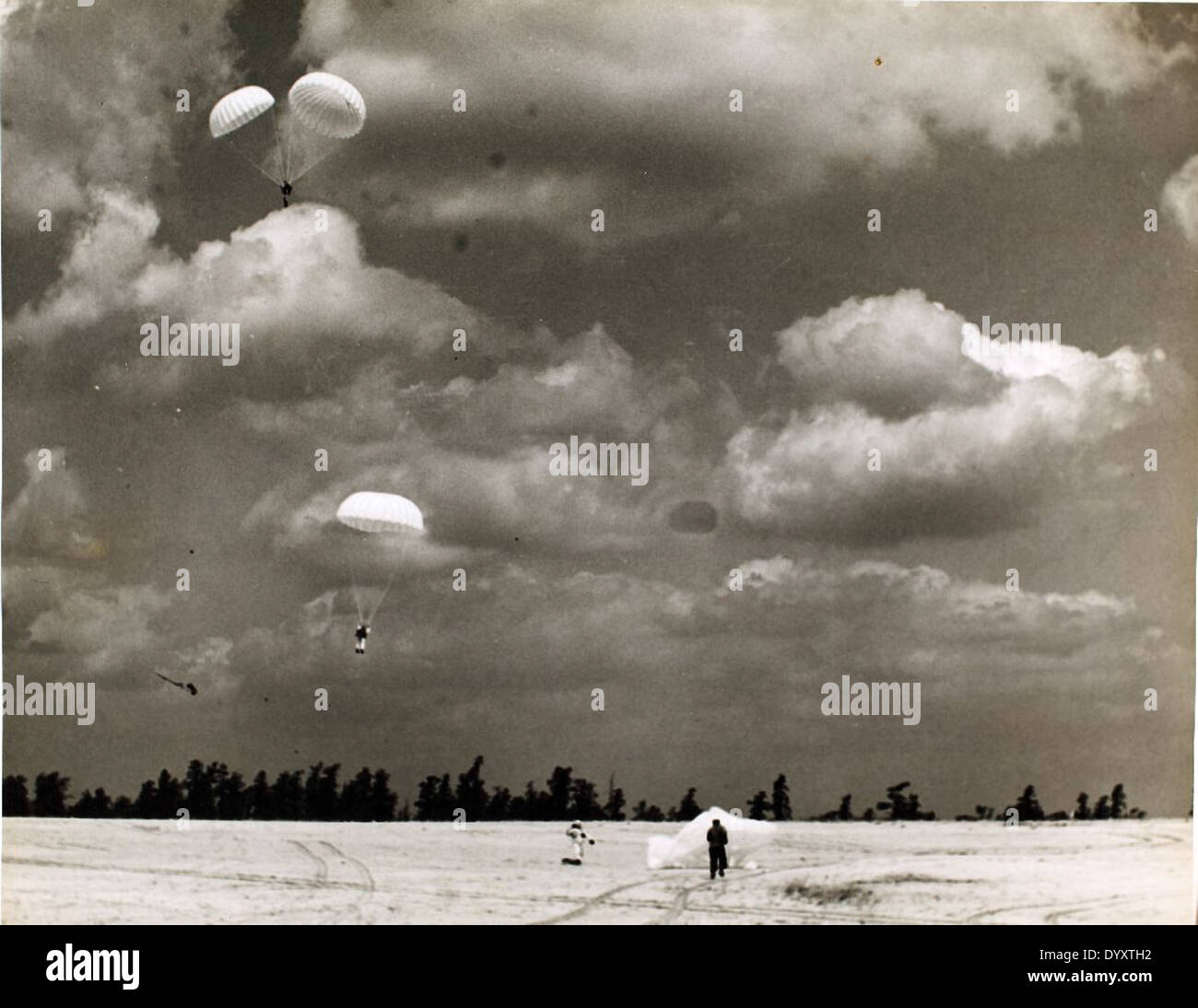 This photo captures military personnel deploying parachutes, with the ...
