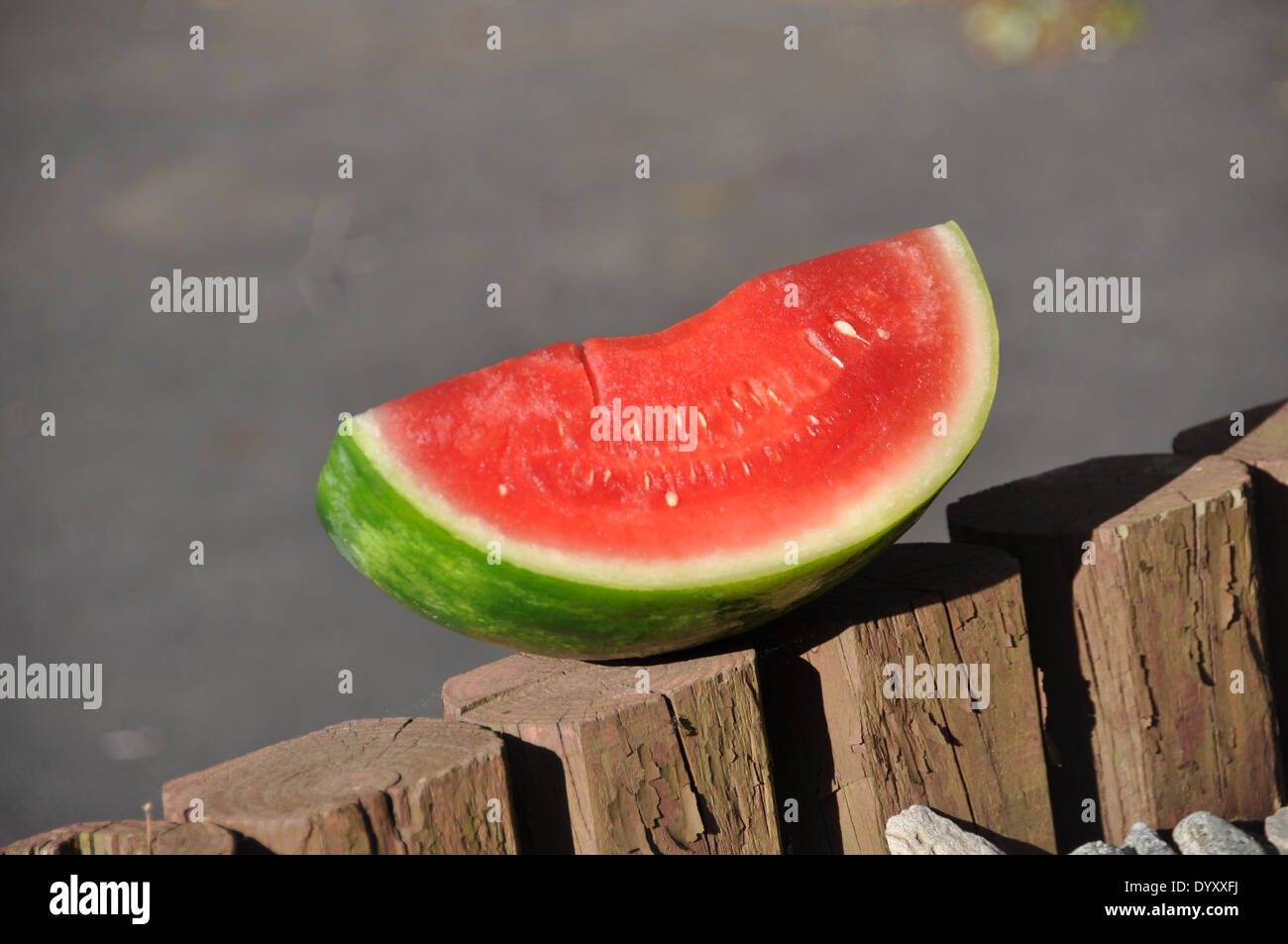 Cut watermelon resting on a wooden post Stock Photo - Alamy