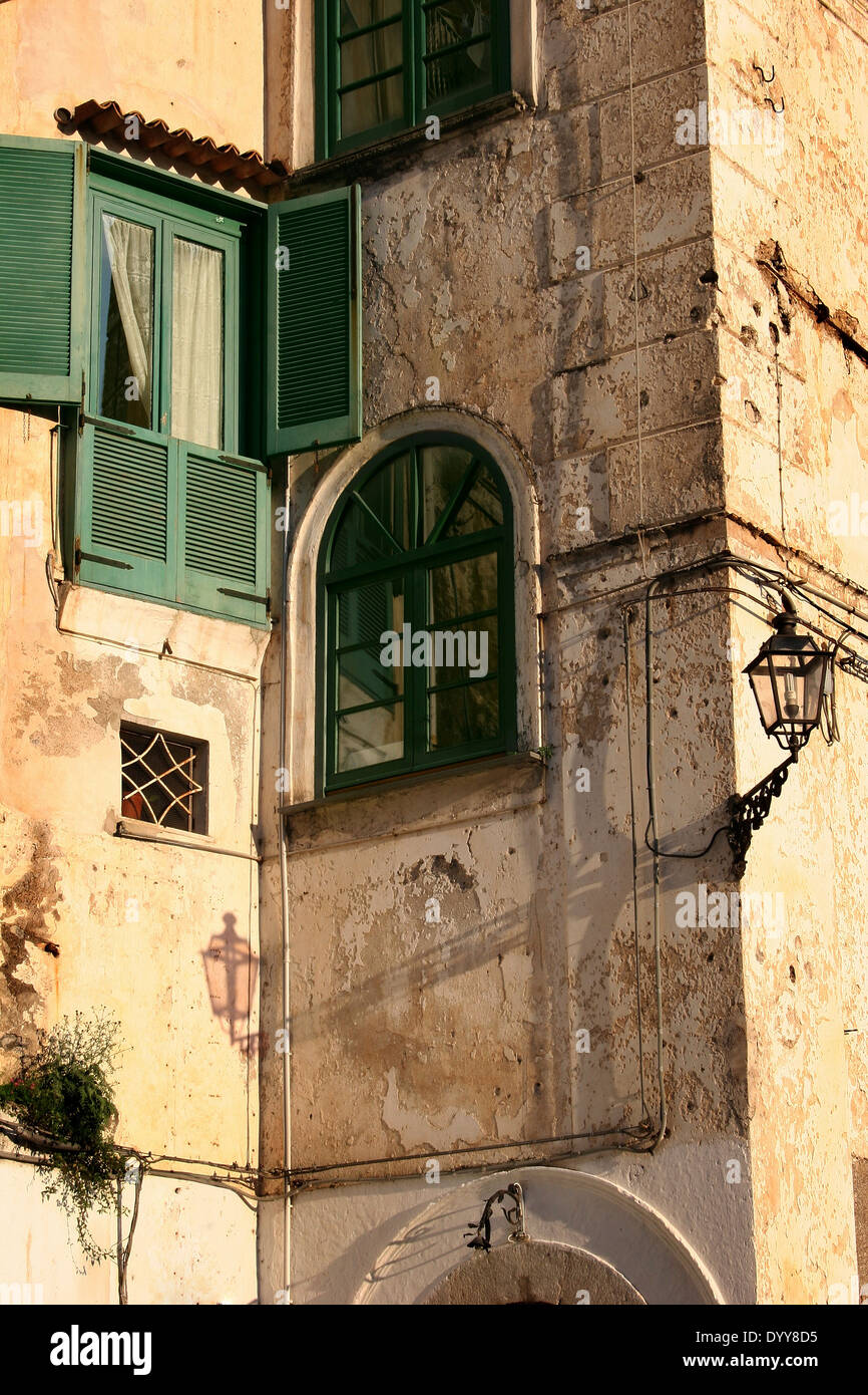 Green shuttered windows on a yellow colored Atrani building, Italy ...