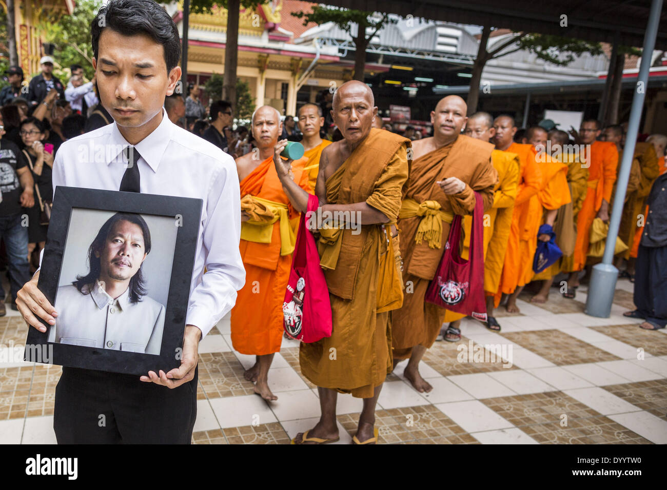 Bangkok, Thailand. 28th Apr, 2014. A mourner carries a photo of Kamol ...
