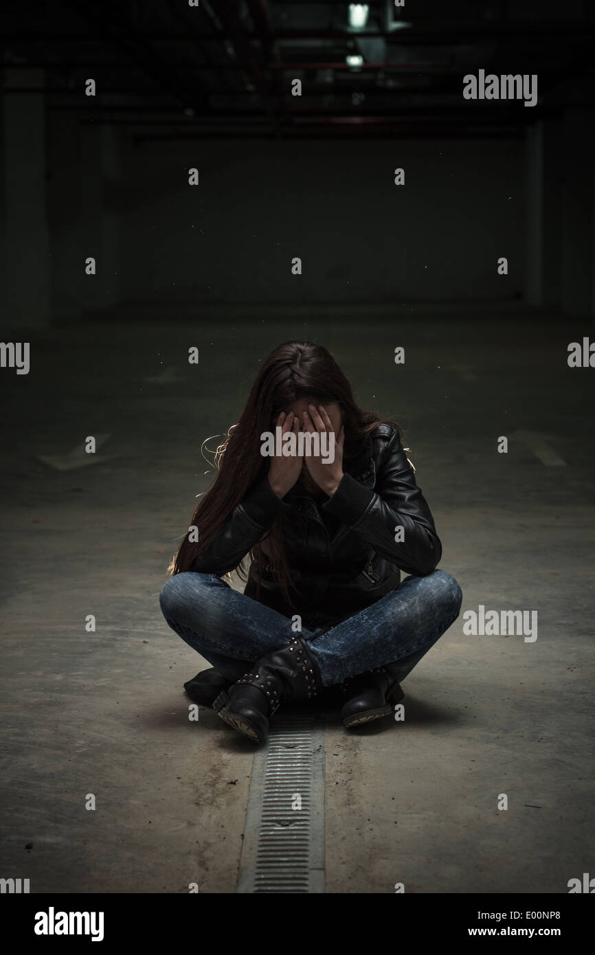 Depressed teenage girl with hands over face sitting on floor Stock ...