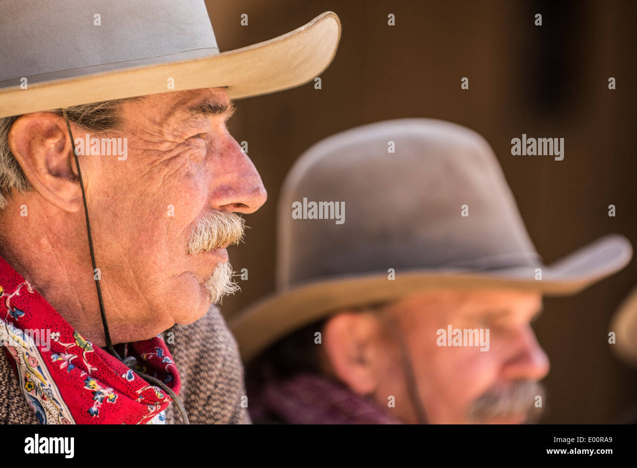 Two middle aged cowboys looking out over the town Stock Photo - Alamy