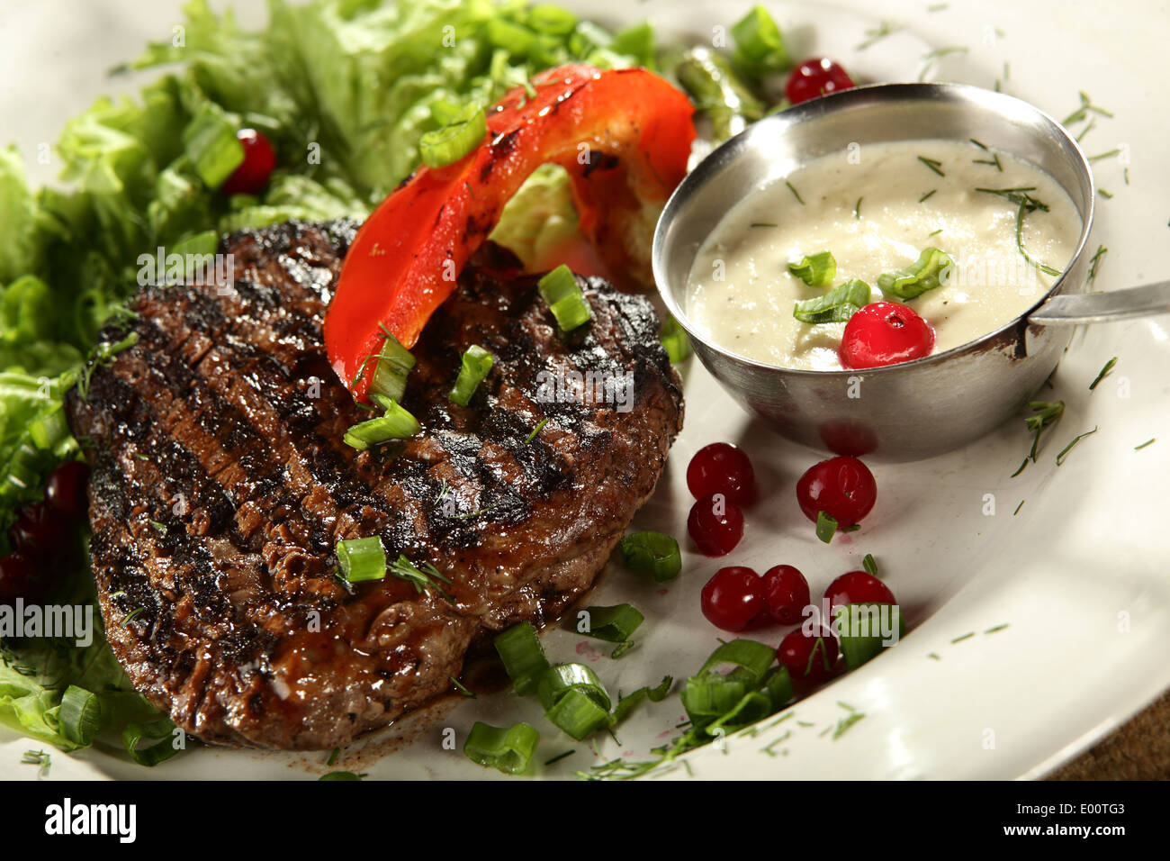 grilled meat in white dish with souce Stock Photo - Alamy