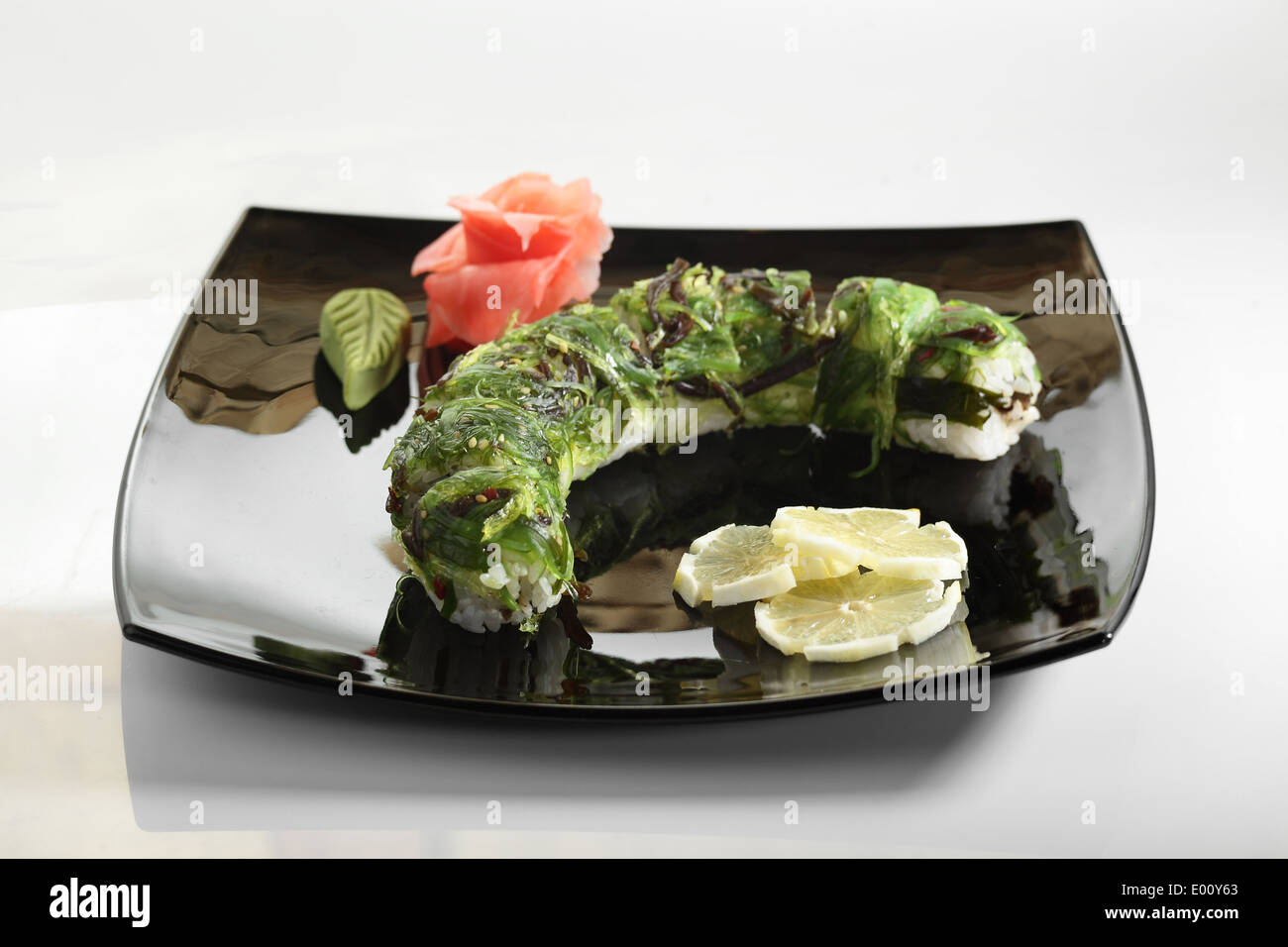 cold sushi on black dish and white background Stock Photo - Alamy