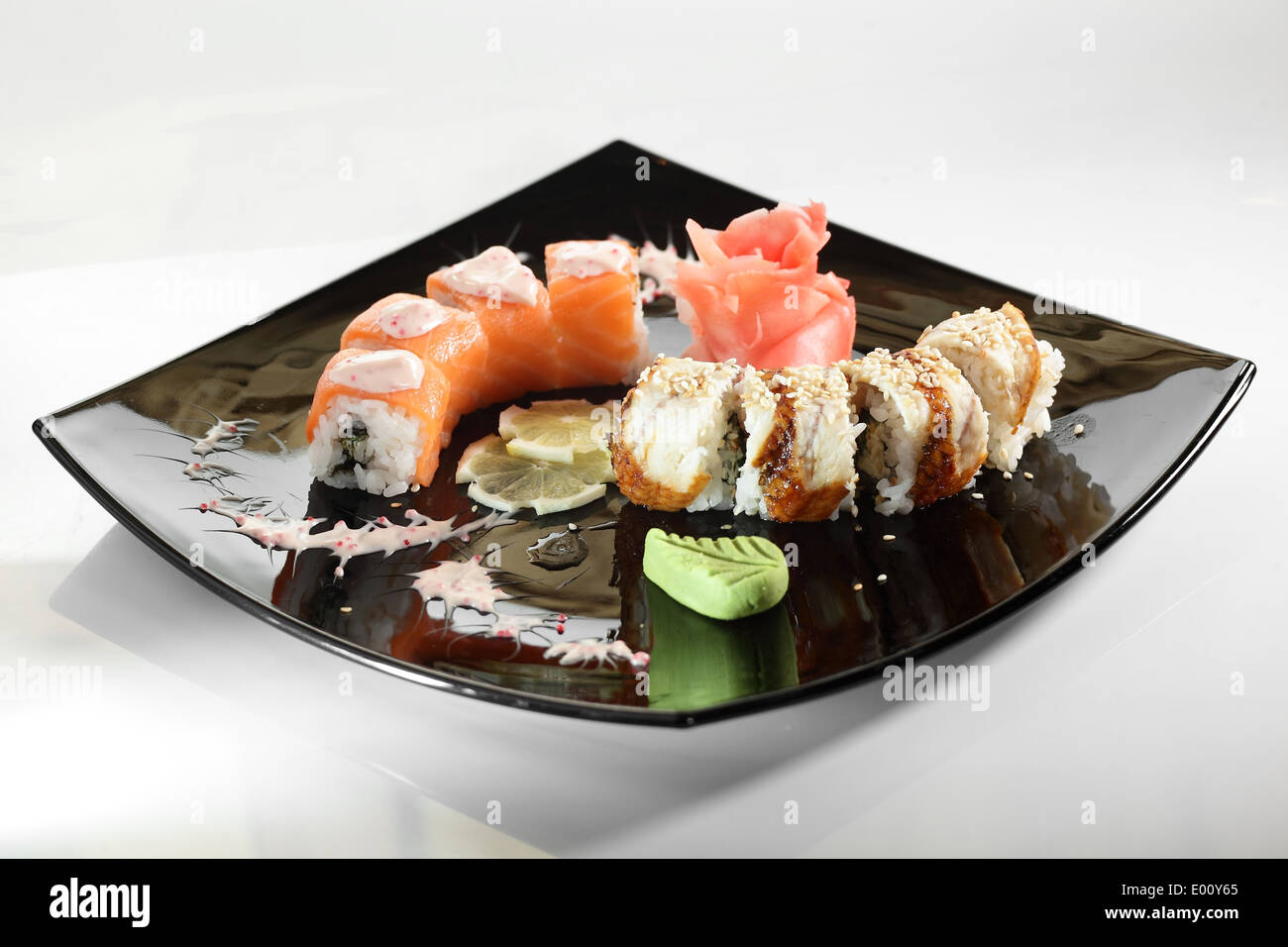 cold sushi on black dish and white background Stock Photo - Alamy