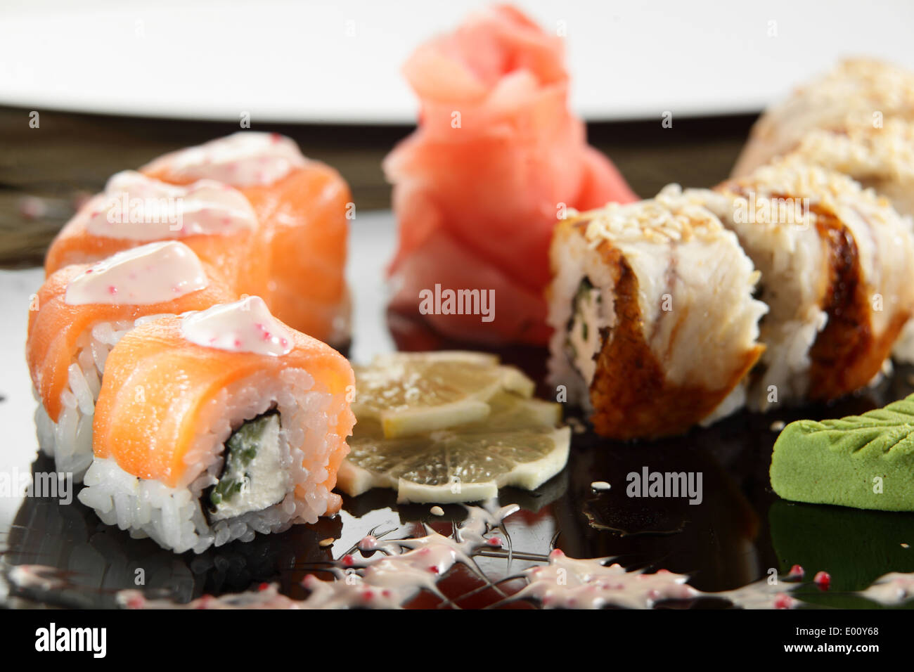 cold sushi on black dish and white background Stock Photo - Alamy