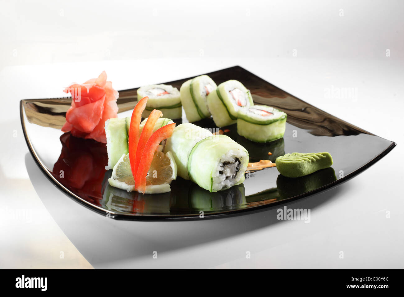 cold sushi on black dish and white background Stock Photo - Alamy
