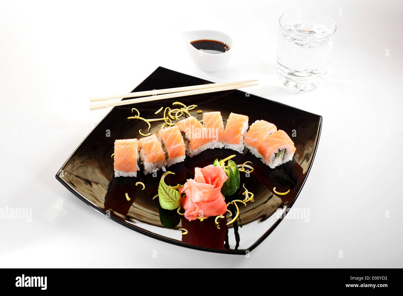 cold sushi on black dish and white background Stock Photo - Alamy