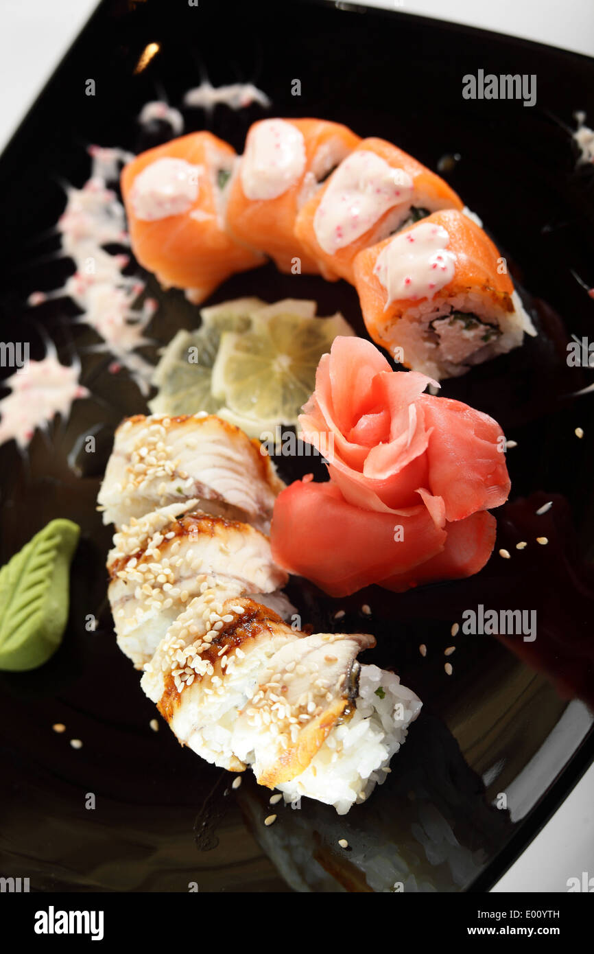 cold sushi on black dish and white background Stock Photo - Alamy