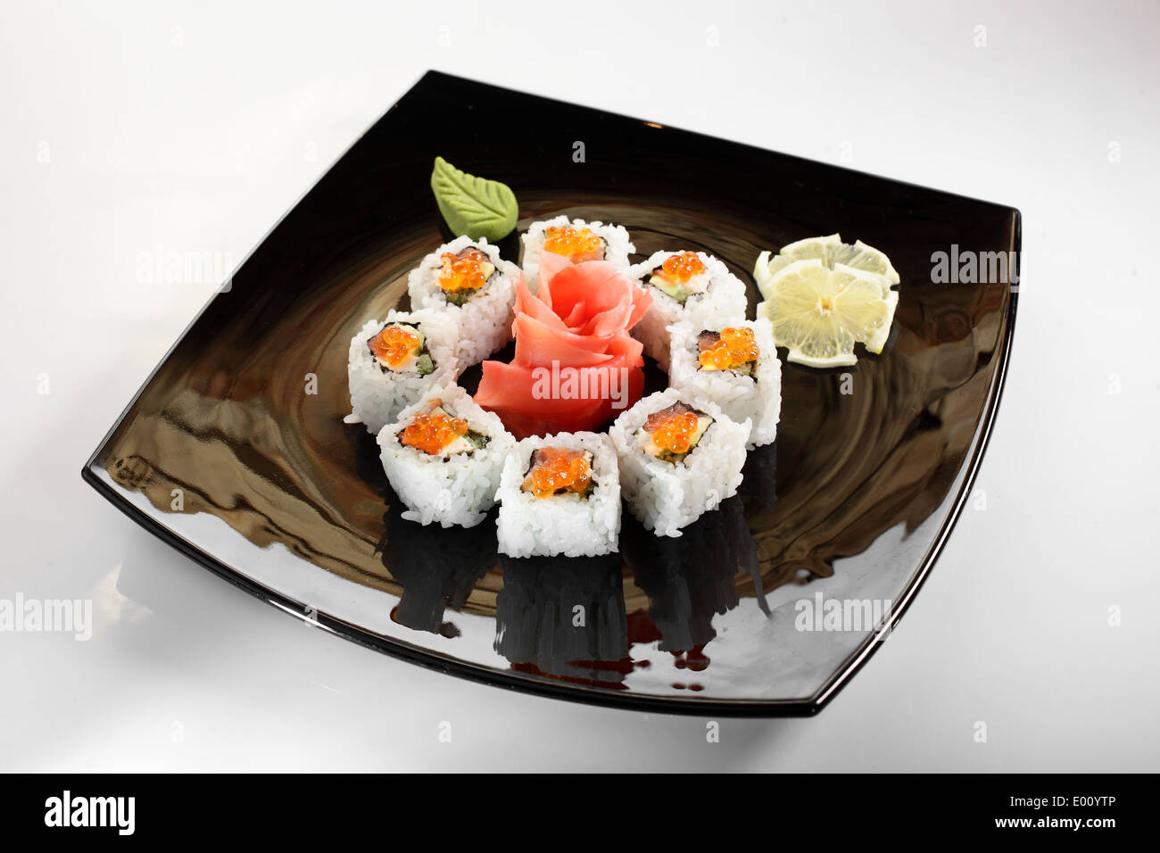 cold sushi on black dish and white background Stock Photo - Alamy