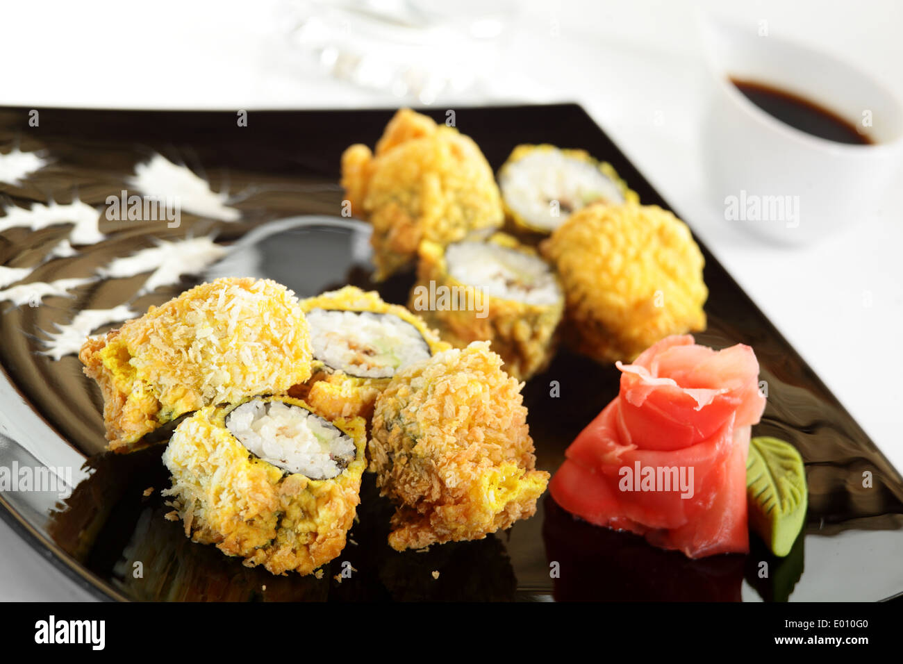 cold sushi on black dish and white background Stock Photo - Alamy