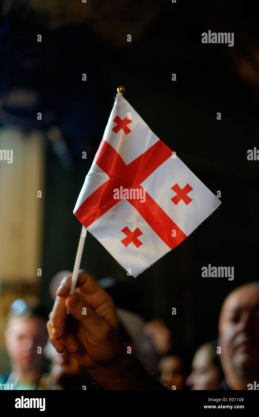 A Georgian pilgrim holding the Georgian national flag in the old city ...