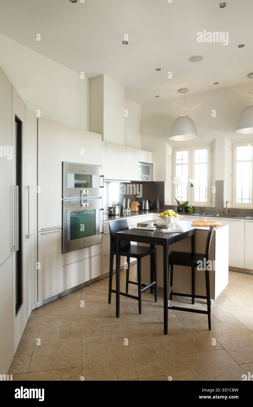 Bright kitchen with cream units and wenge breakfast bar. Lights on ...