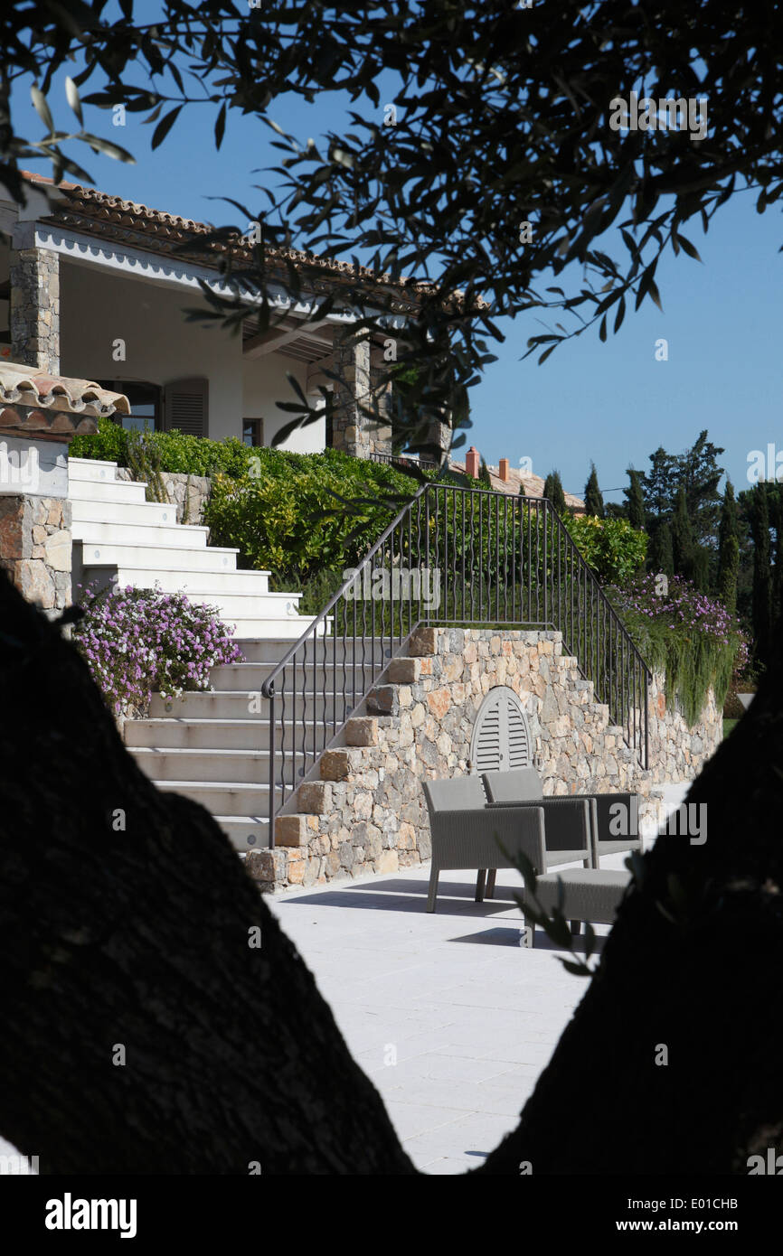 Steps down from veranda to poolside terrace seen through the fork in ...