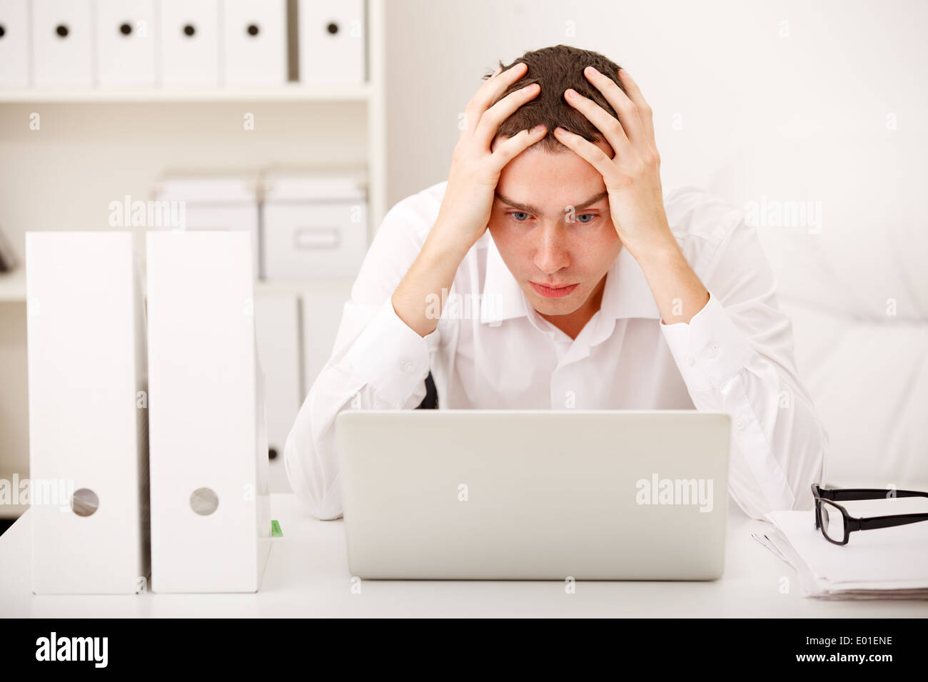 Despairing businessman sitting at desk Stock Photo - Alamy