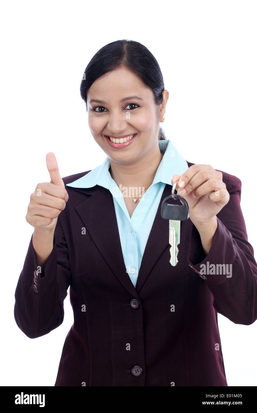 Happy young Indian business woman holding key against white background ...