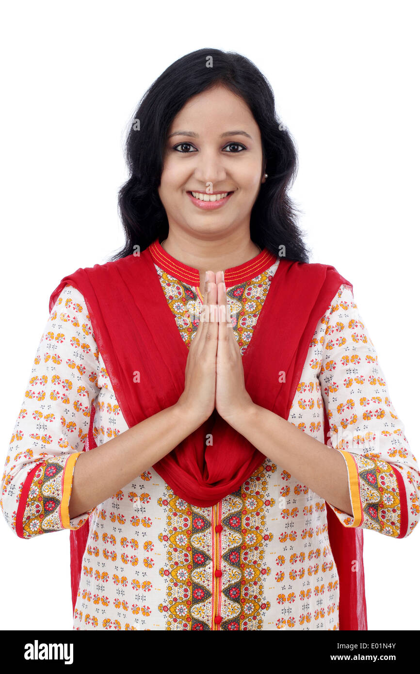 Smiling young woman greeting "Namasthe" against white background Stock ...