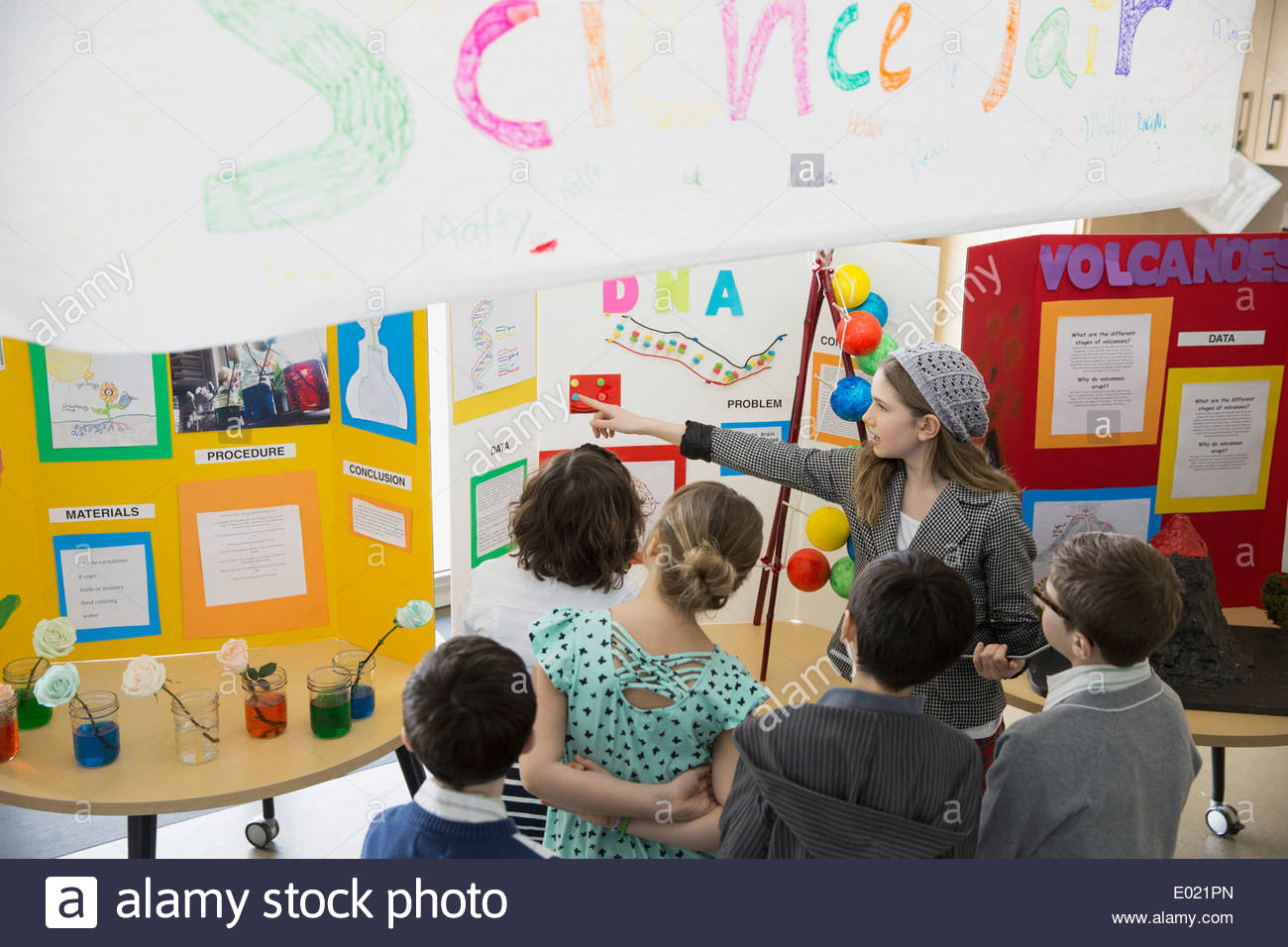 School girl explaining science fair project to classmates Stock Photo ...