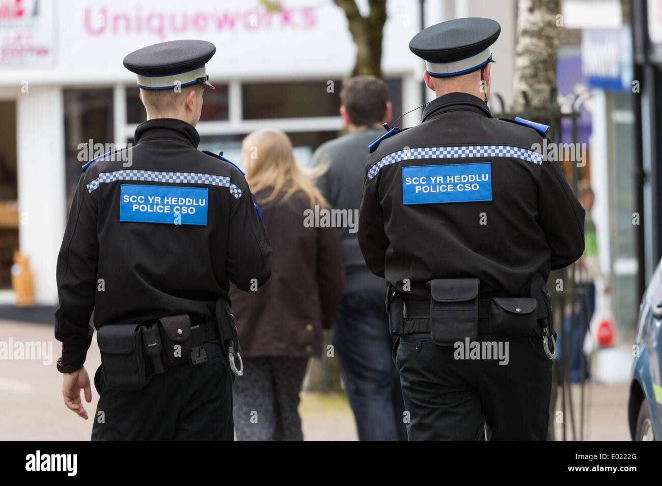 Two Community Support Officers patrol through a town in Wales Stock ...