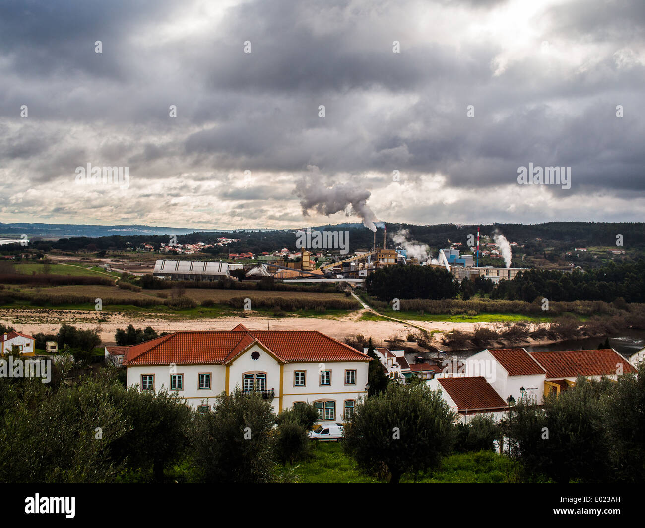 A factory in a rural area sends smoke to the air and at the sametime ...