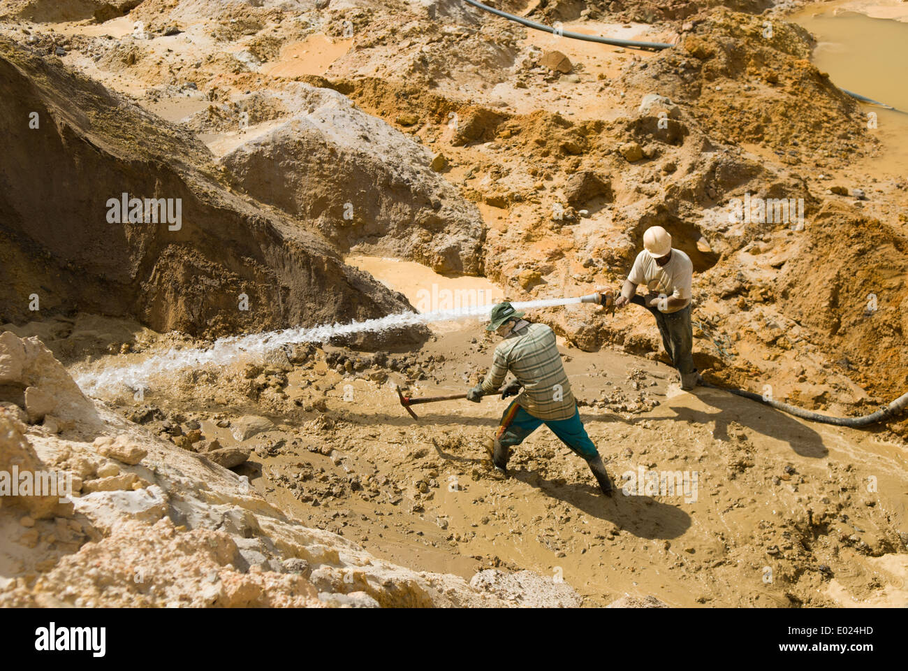Sand and crystal extraction by two men with high powered hoses and pick ...