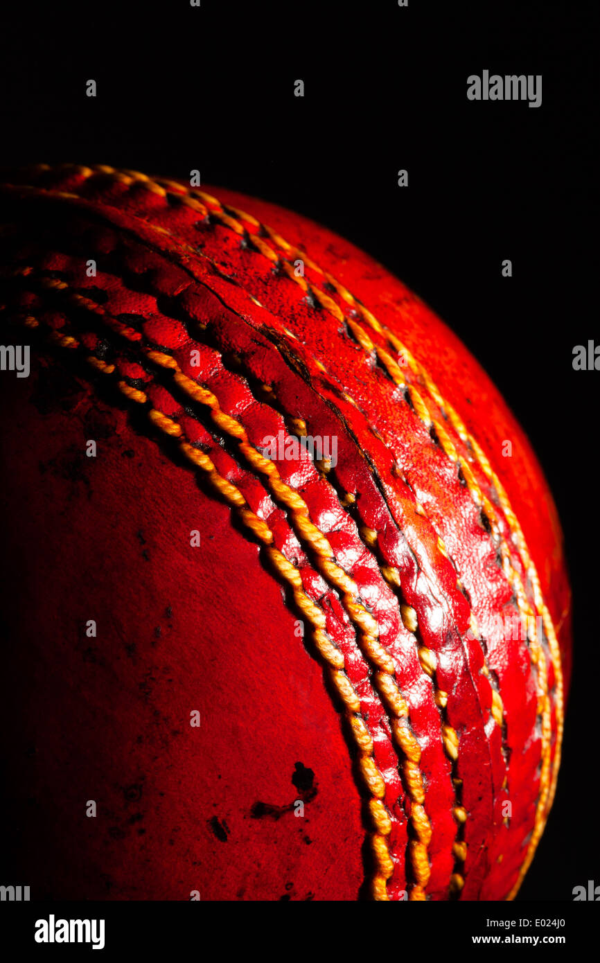 red ball cricket on a black background Stock Photo - Alamy
