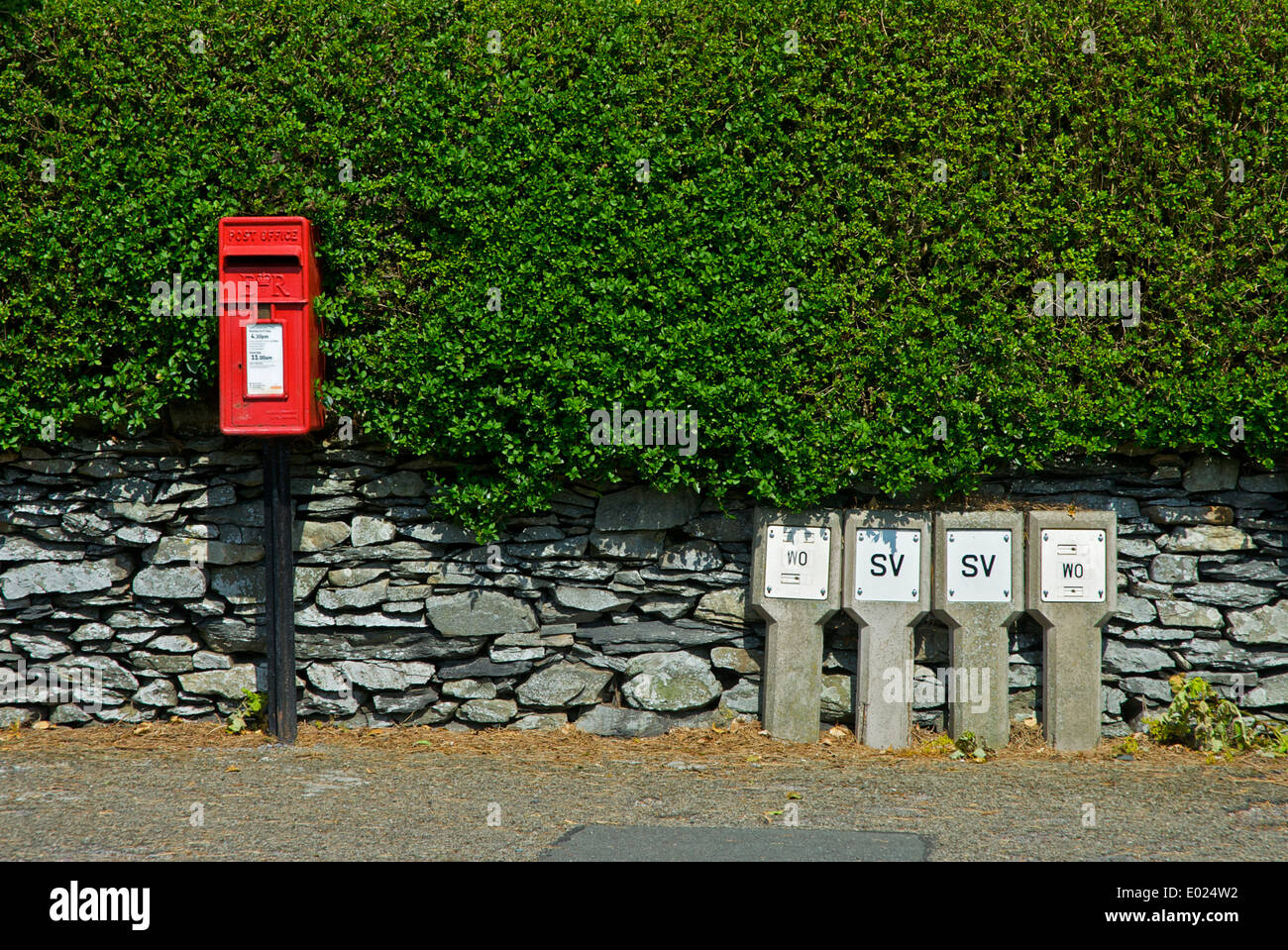Postbox, hedge and safety valve signs, Cumbria, England UK Stock Photo ...