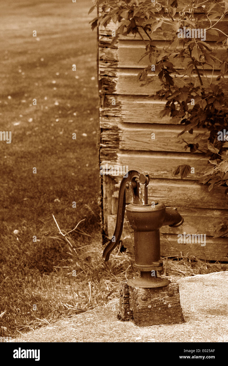 An antique cast iron hand pump on a concrete cistern on a farm in ...