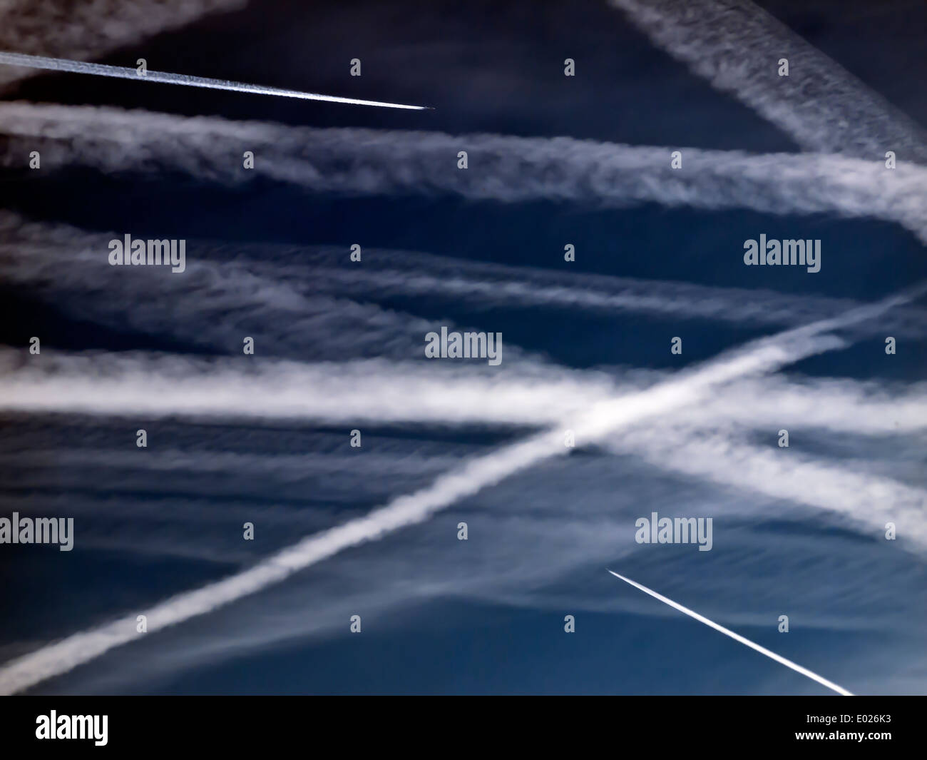 Pattern of many contrails/vapor trails of jet airplanes in the blue sky ...