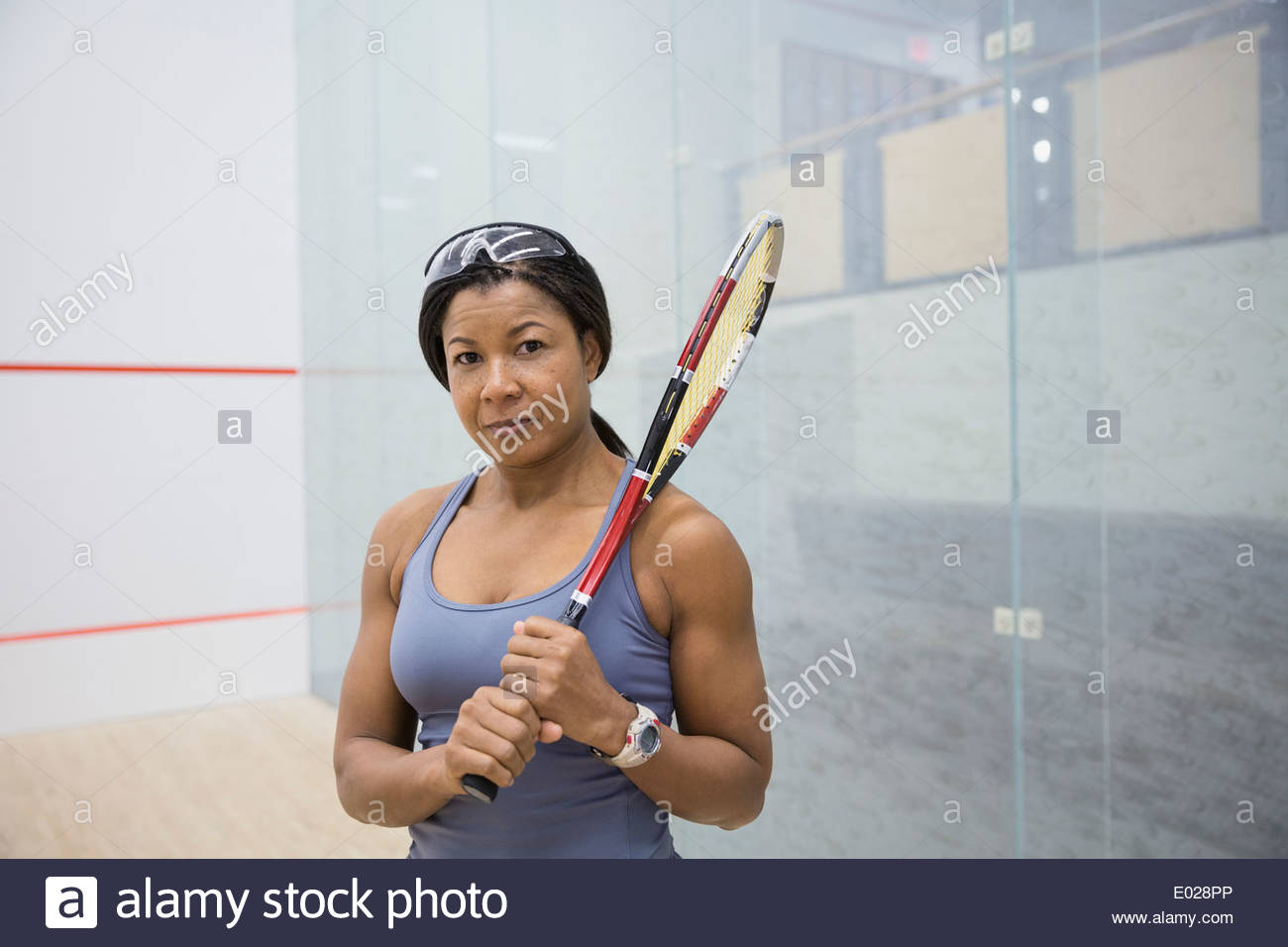 Portrait of confident woman holding squash racket Stock Photo - Alamy