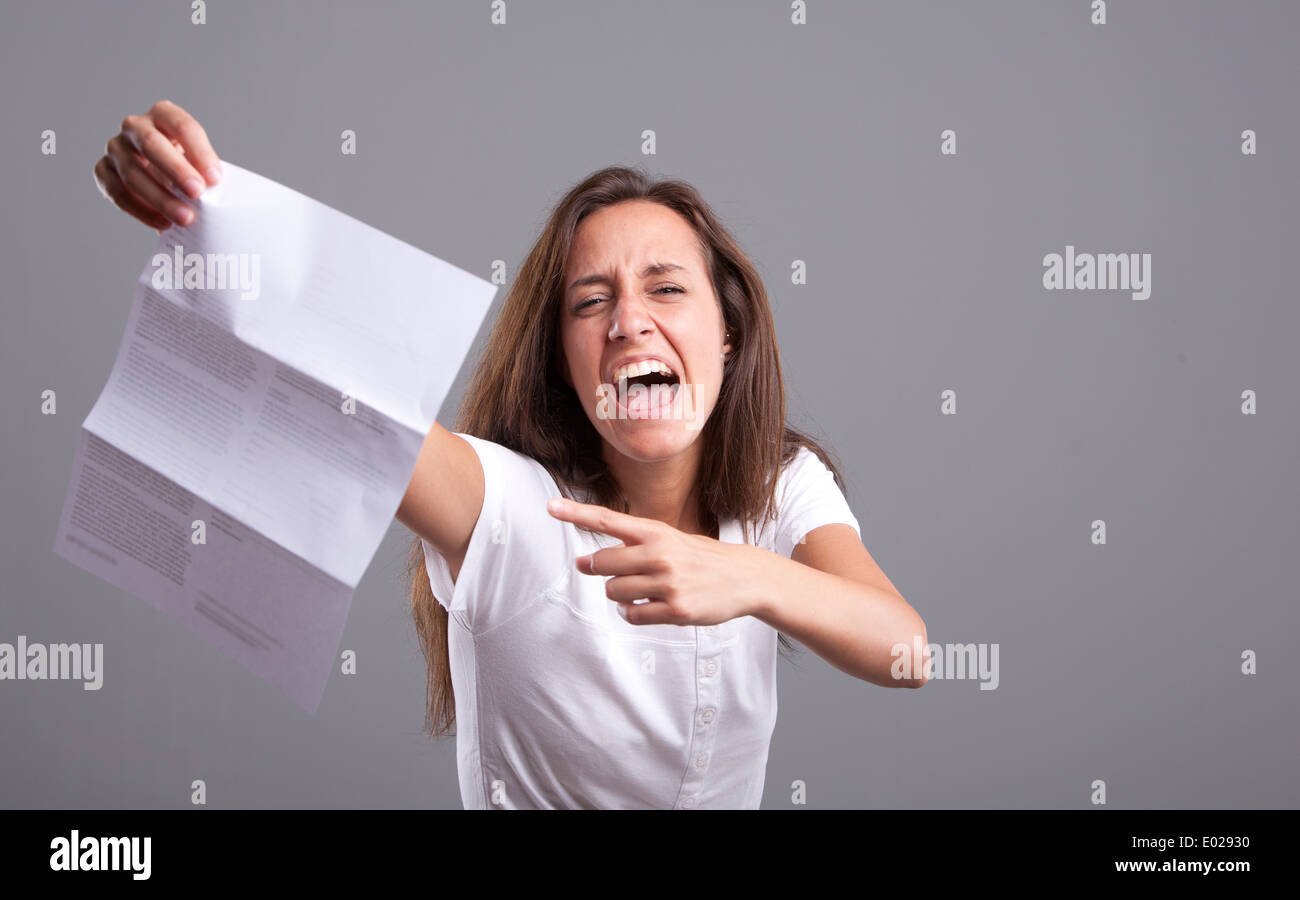 Angry girl pointing out a letter containing bad news or something ...