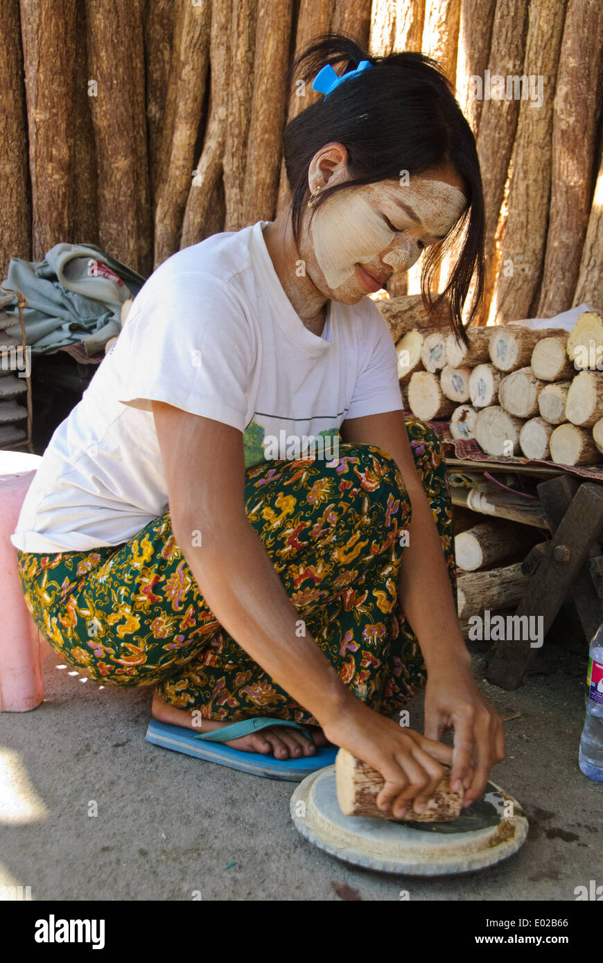 A Burmese girl rubbing the Thanaka bark on a grind stone Stock Photo ...