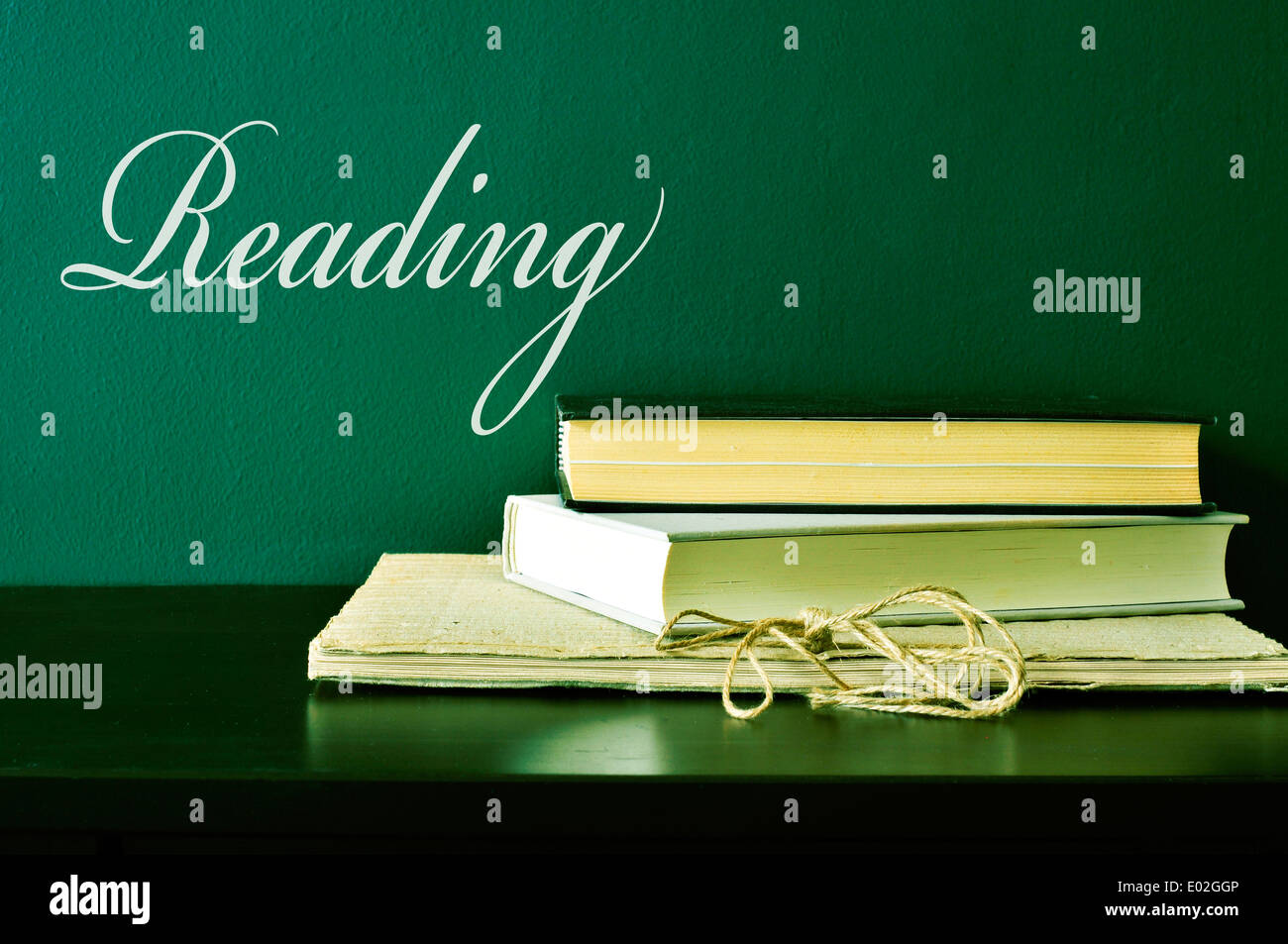 the word reading and a pile of books on a desk Stock Photo - Alamy