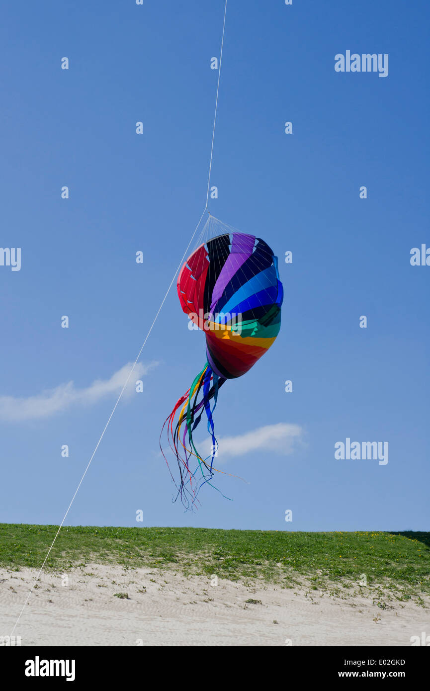 Rainbow colored static Kite in blue sky Stock Photo - Alamy