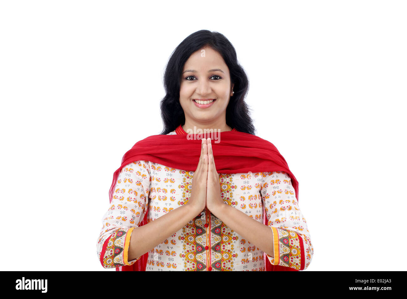 Smiling young woman greeting "Namasthe" against white background Stock ...