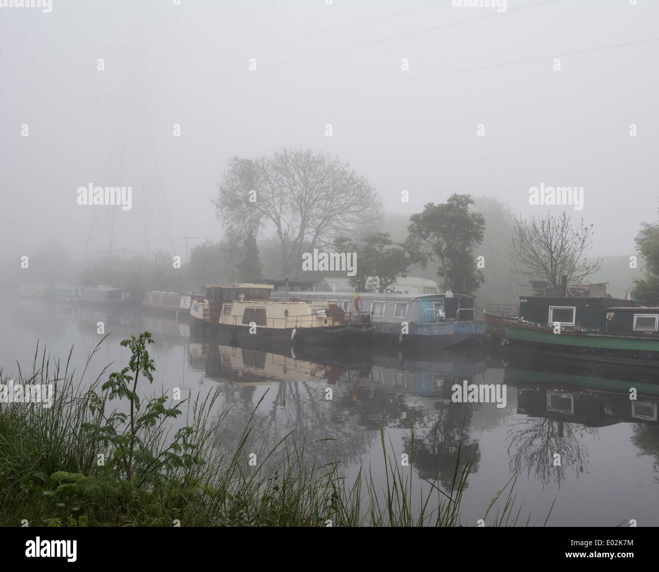 London UK. 30 April 2014.Canal boats shrouded in mist on the river Lee ...