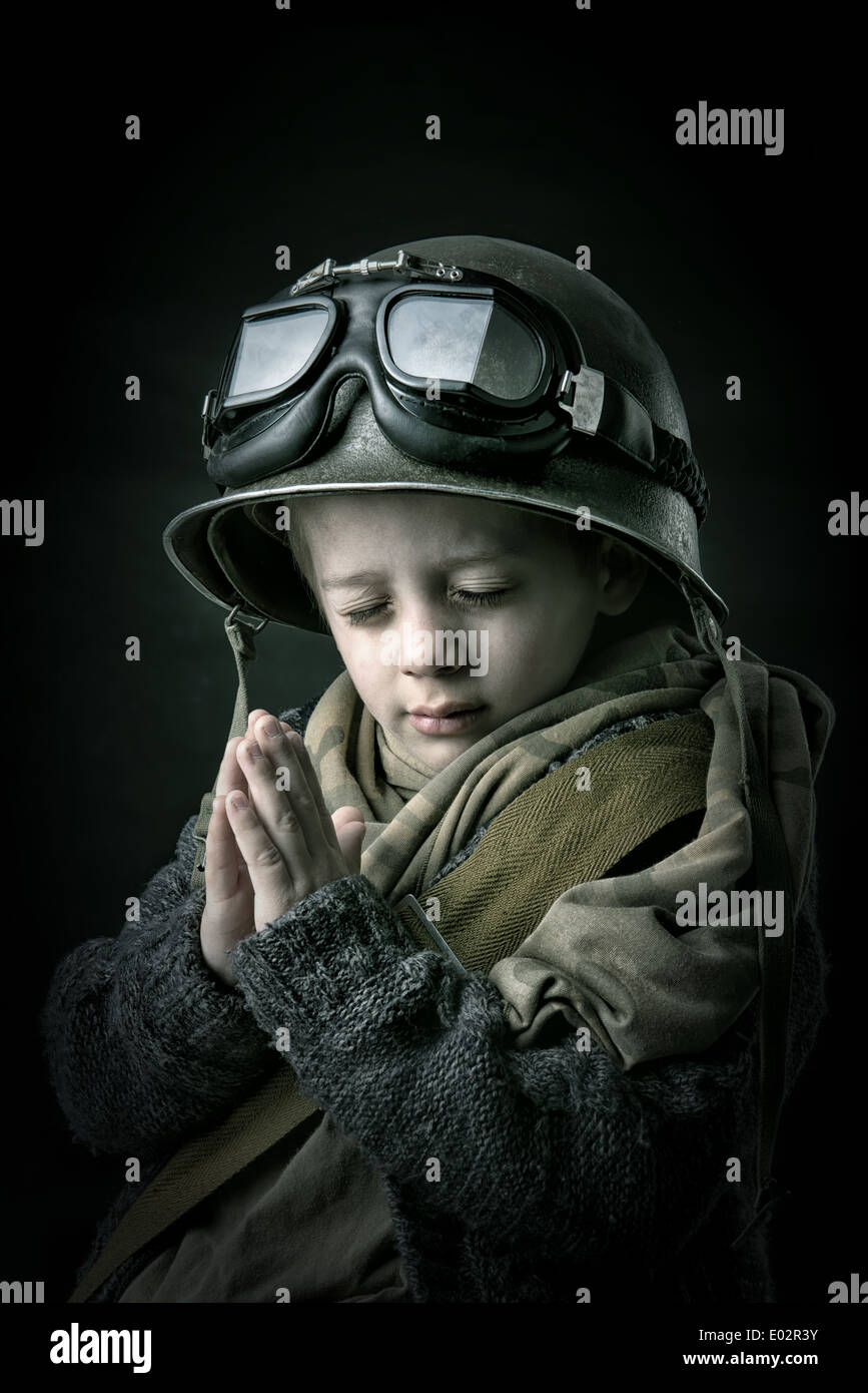 Young boy soldier praying Stock Photo - Alamy