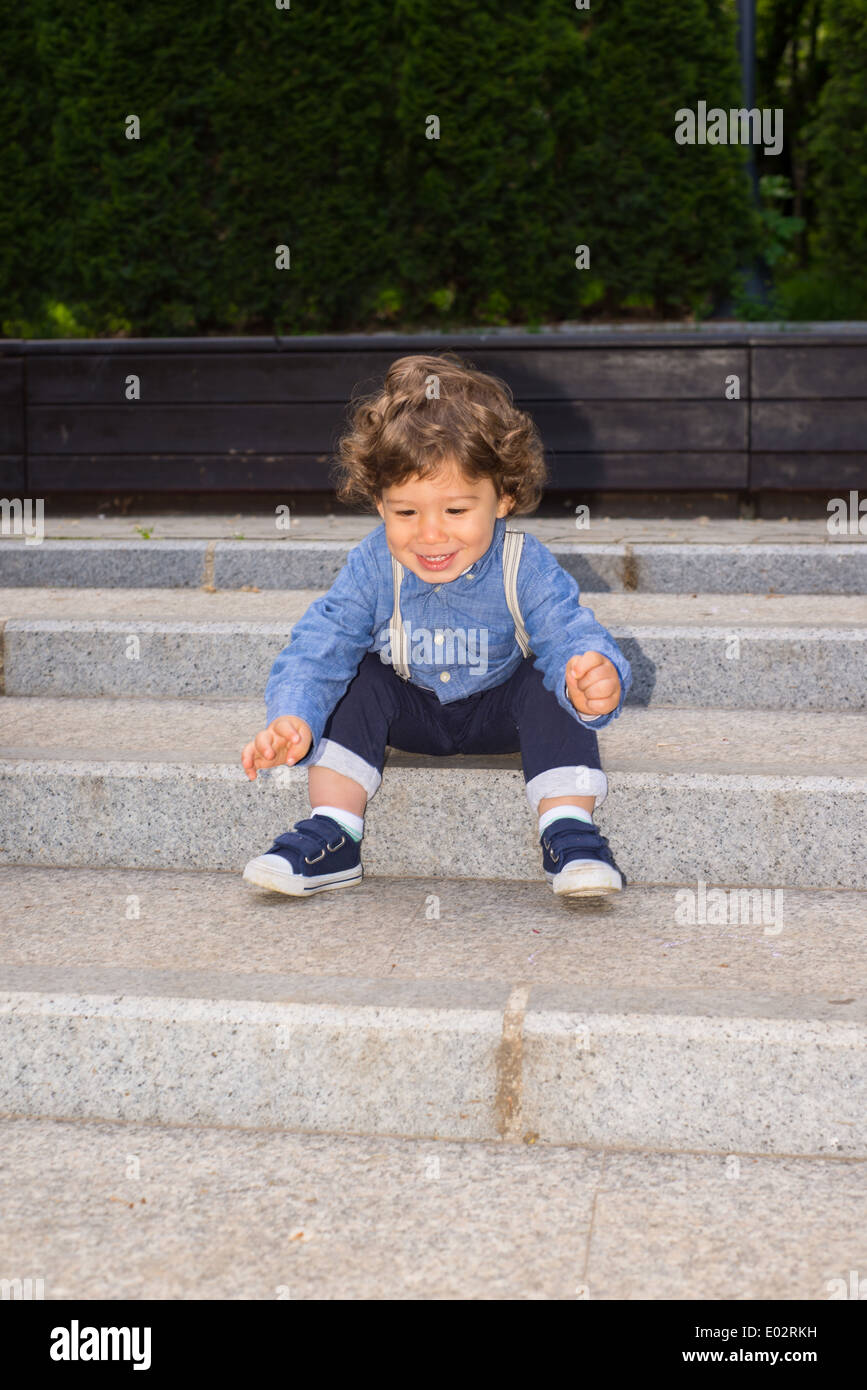 Happy toddler on stairs trying to get up Stock Photo - Alamy