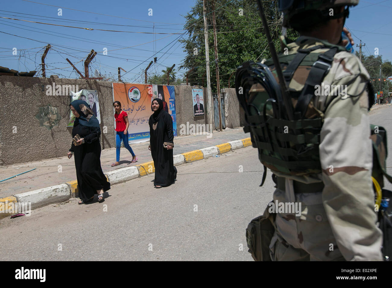 Baghdad, Iraq. 30th Apr, 2014. Iraqi people walk past security forces ...